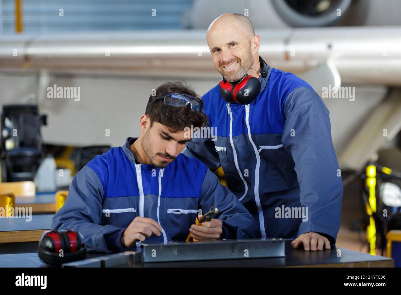 2 mechanic men try to fix and setup an engine Stock Photo - Alamy