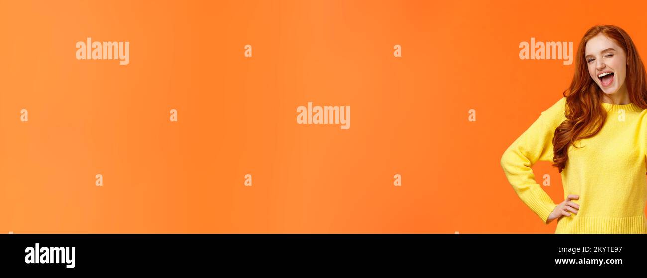 Saying yes. Cheerful redhead woman in yellow sweater giving thumb-up ...