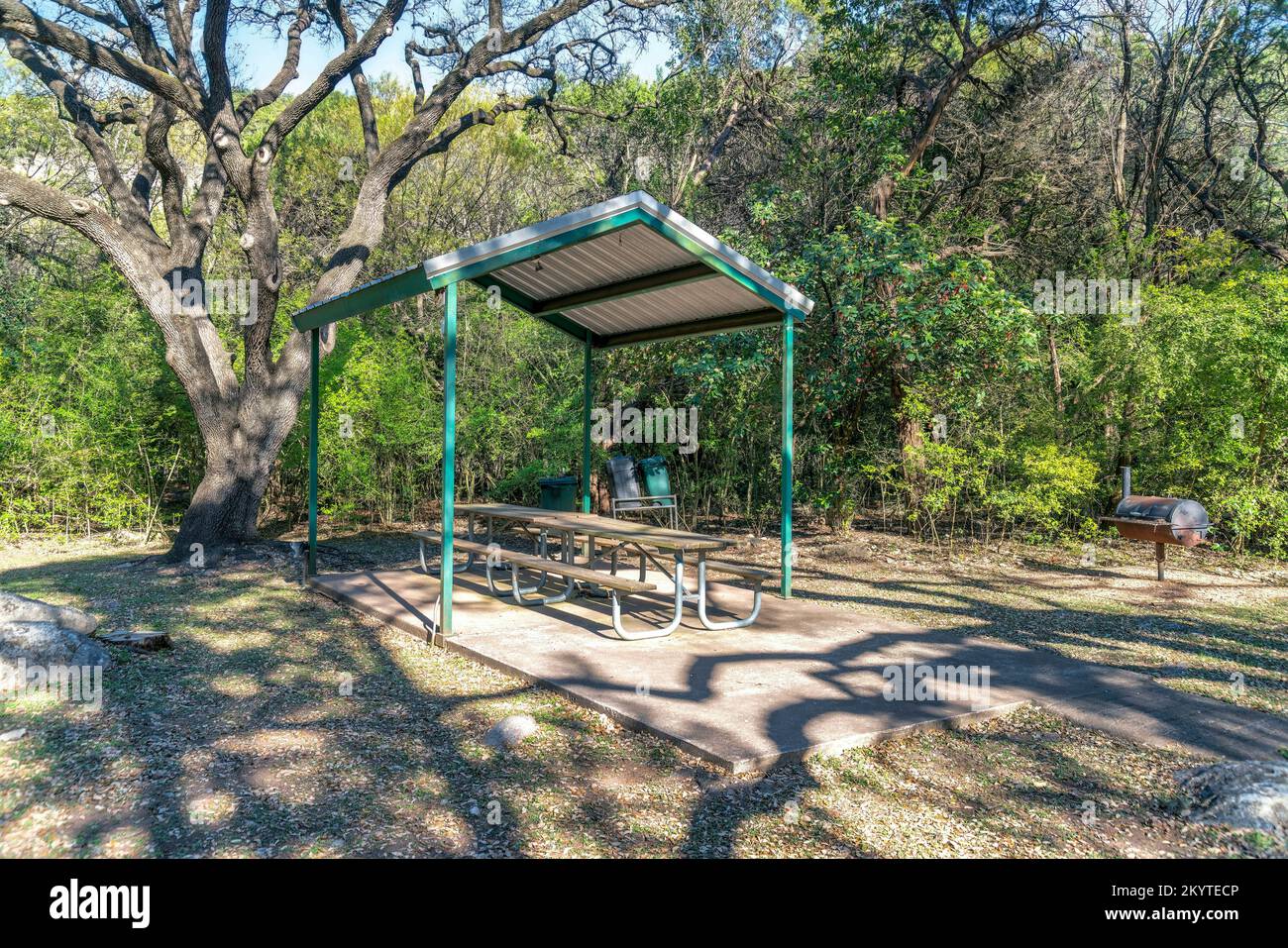 Austin, Texas- Picnic table with seats under a roof in a community park ...