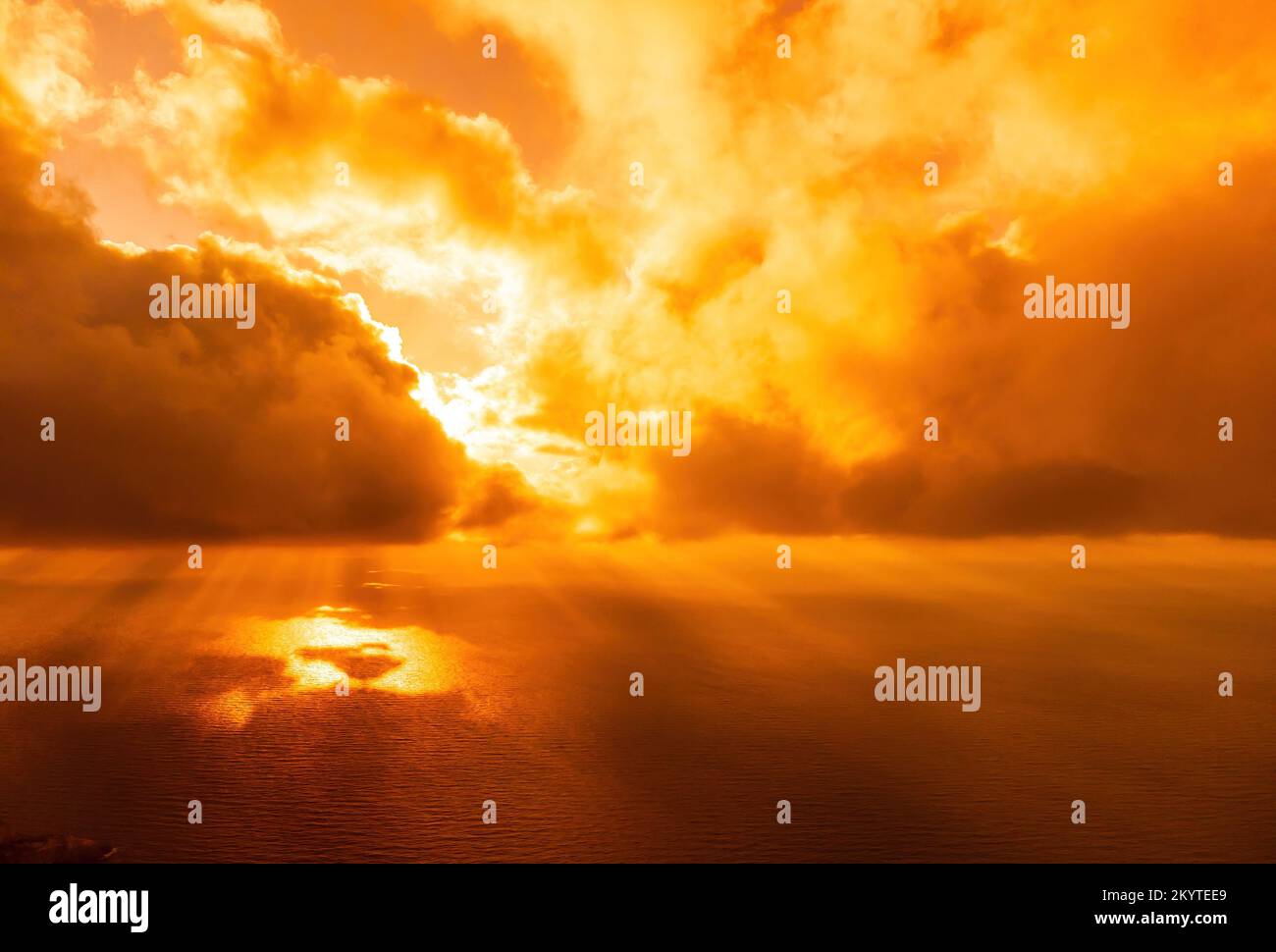 Aerial view red burning sunset over the sea with rocky volcanic cliff ...