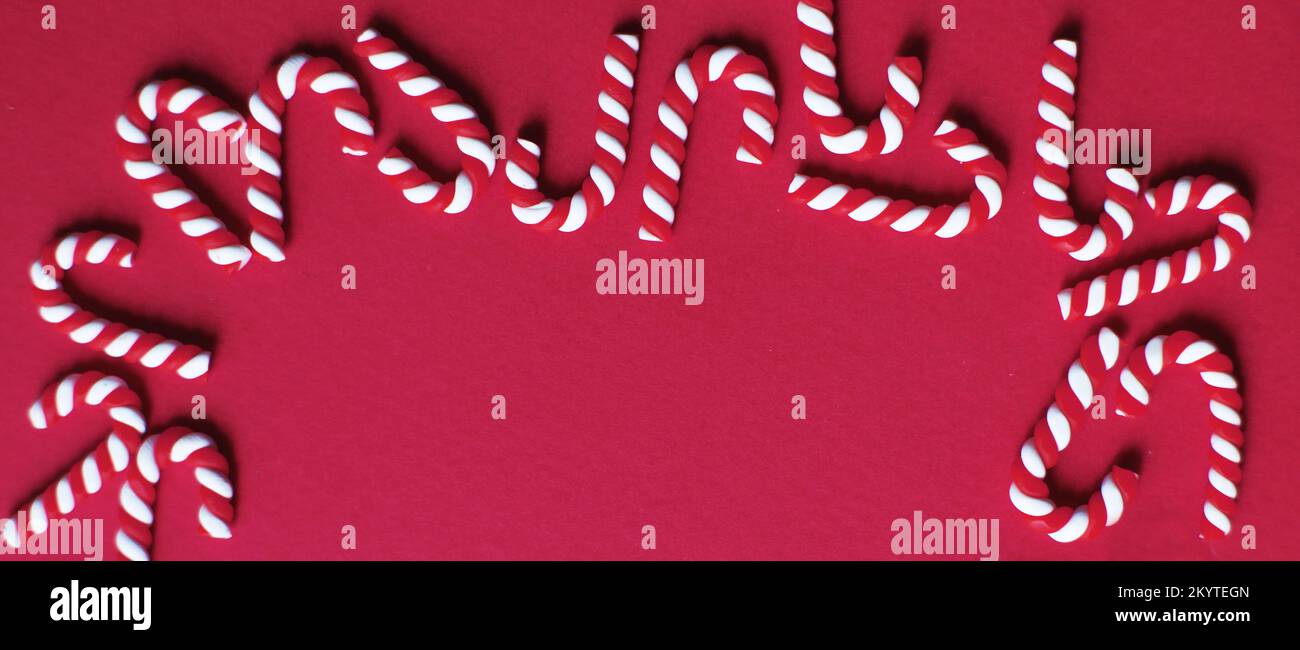 Flat lay Christmas composition with frame of candy canes on a red ...