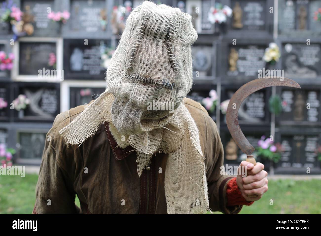 Spooky masked man in cemetery entrance Stock Photo - Alamy