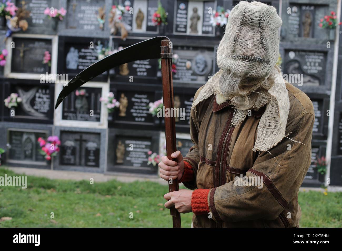 Spooky masked man in cemetery entrance Stock Photo - Alamy