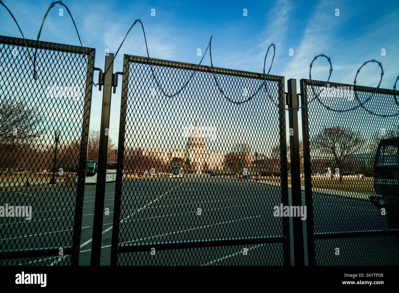 The U.S. Capitol building at sunset, fortified behind a metal fence ...
