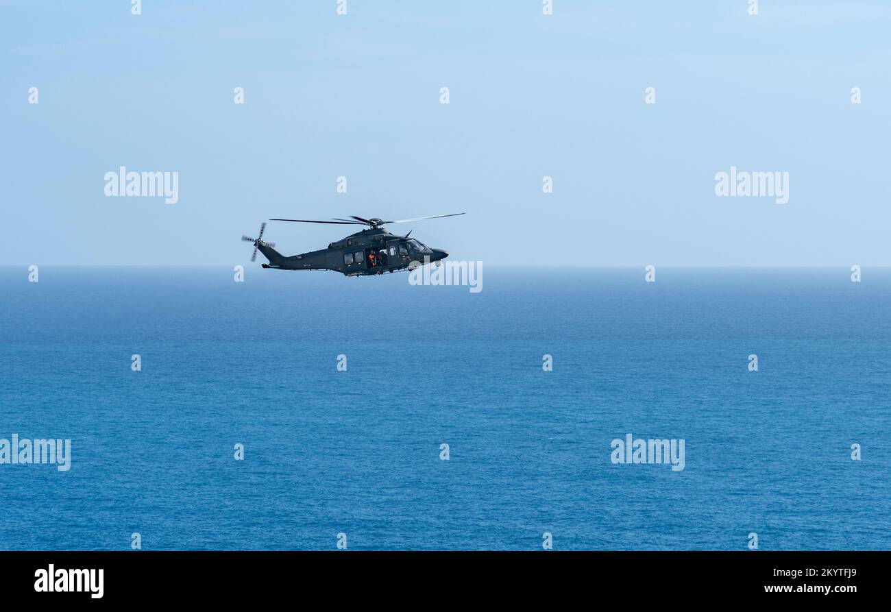 Helicopter with open door flying over sea seen in Italy Stock Photo - Alamy