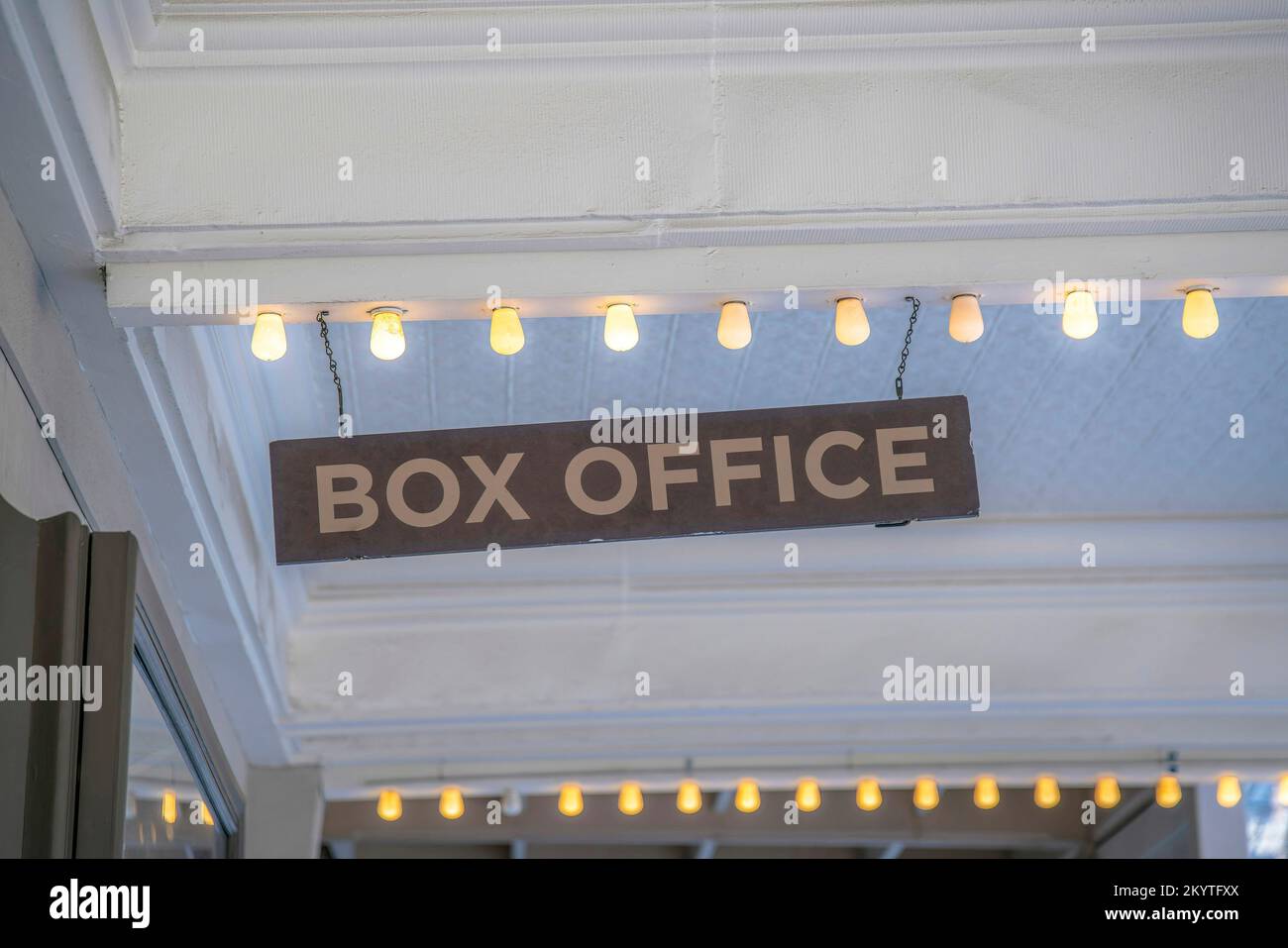 Hanging Box Office signage on a ceiling with row of light bulbs. Uneven ...