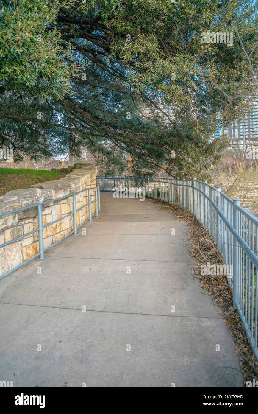 Austin, Texas- Concrete walkway with metal railings along the trees on ...