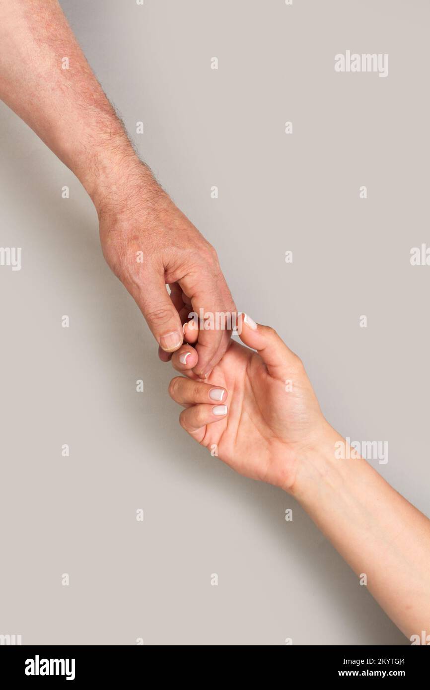 Woman hand holding man hand on a gray background with copy space Stock ...