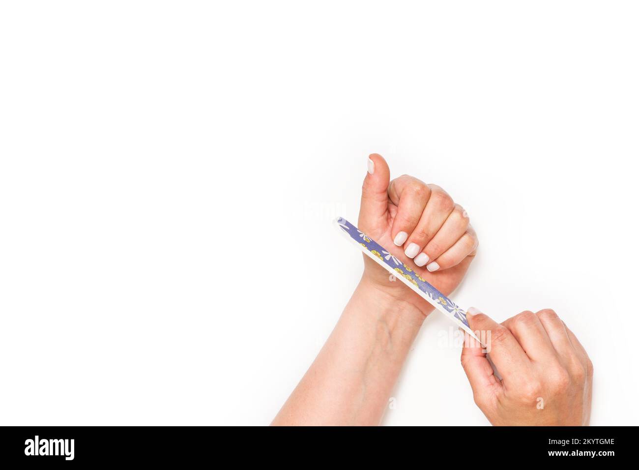 Woman filing her nails with a colored file on a white background with ...