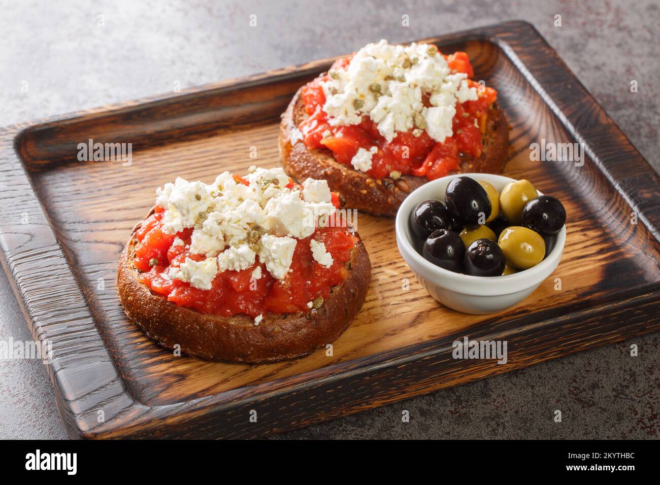 Dakos consists of a slice of cracked barley bread and garnished with ...