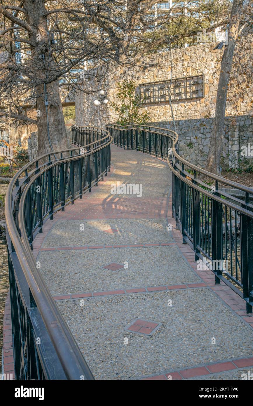 Concrete pavement with barrier railings near the trees at River Walk ...