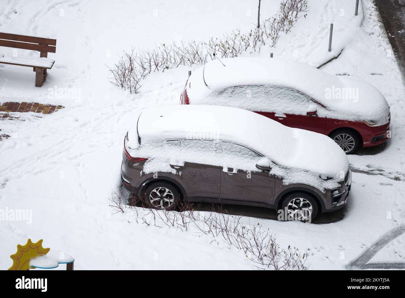City street driveway parking lot spot with small car covered snow stuck ...
