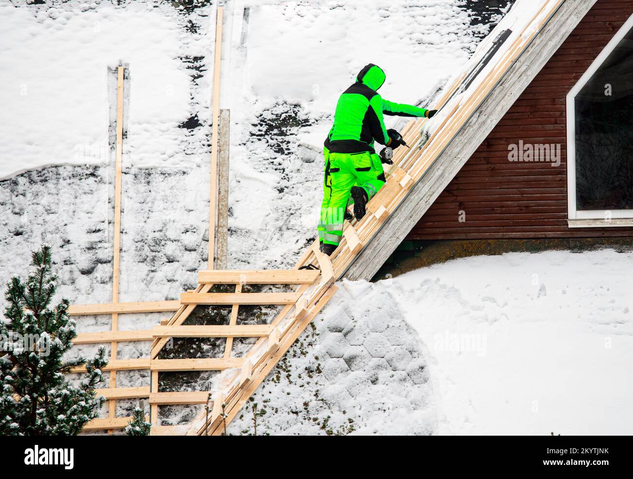 Workers reroofing or do an overlay for old roof. Building new tilted ...