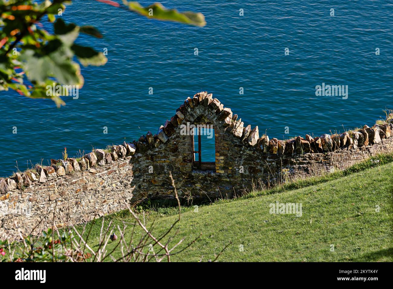 Medieval wall with window to the sea in Howth, Ireland. The wall stands ...