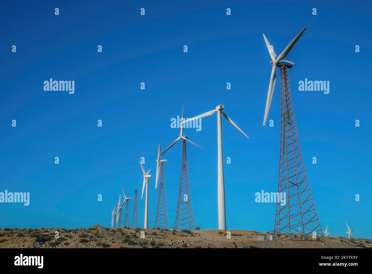Windmill with tubular steel and lattice towers in a row on a desert at ...