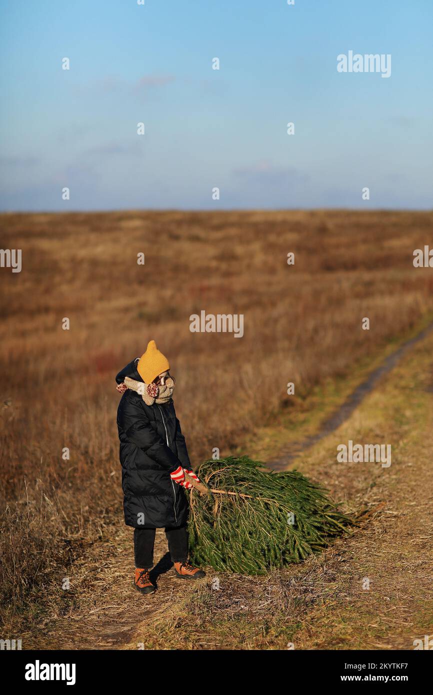 Adorable little girl in winter coat, yellow hat and knitted mittens ...