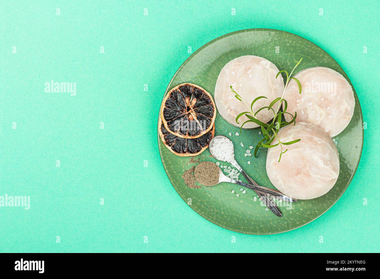 Chunks of frozen hake. Marine fish fillet on turquoise color background ...