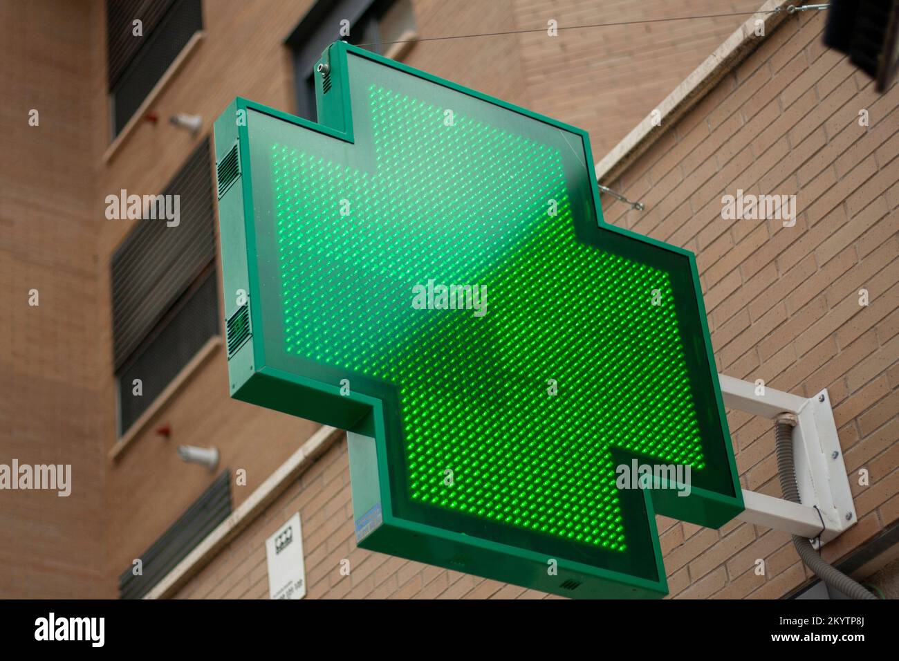 luminous green cross indicating that a pharmacy remains open in the ...