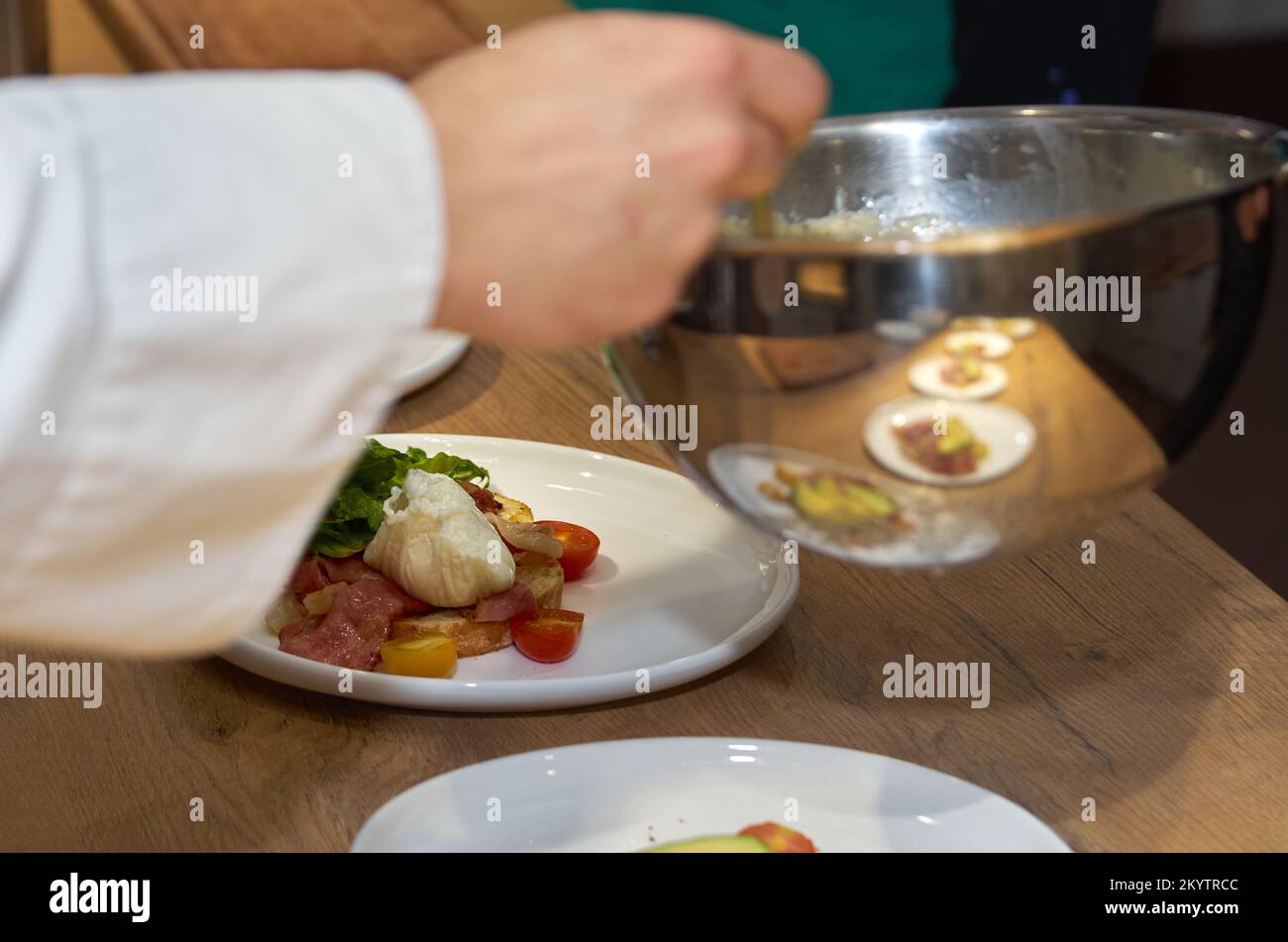 The process of cooking: laying out the finished dish on plates Stock ...