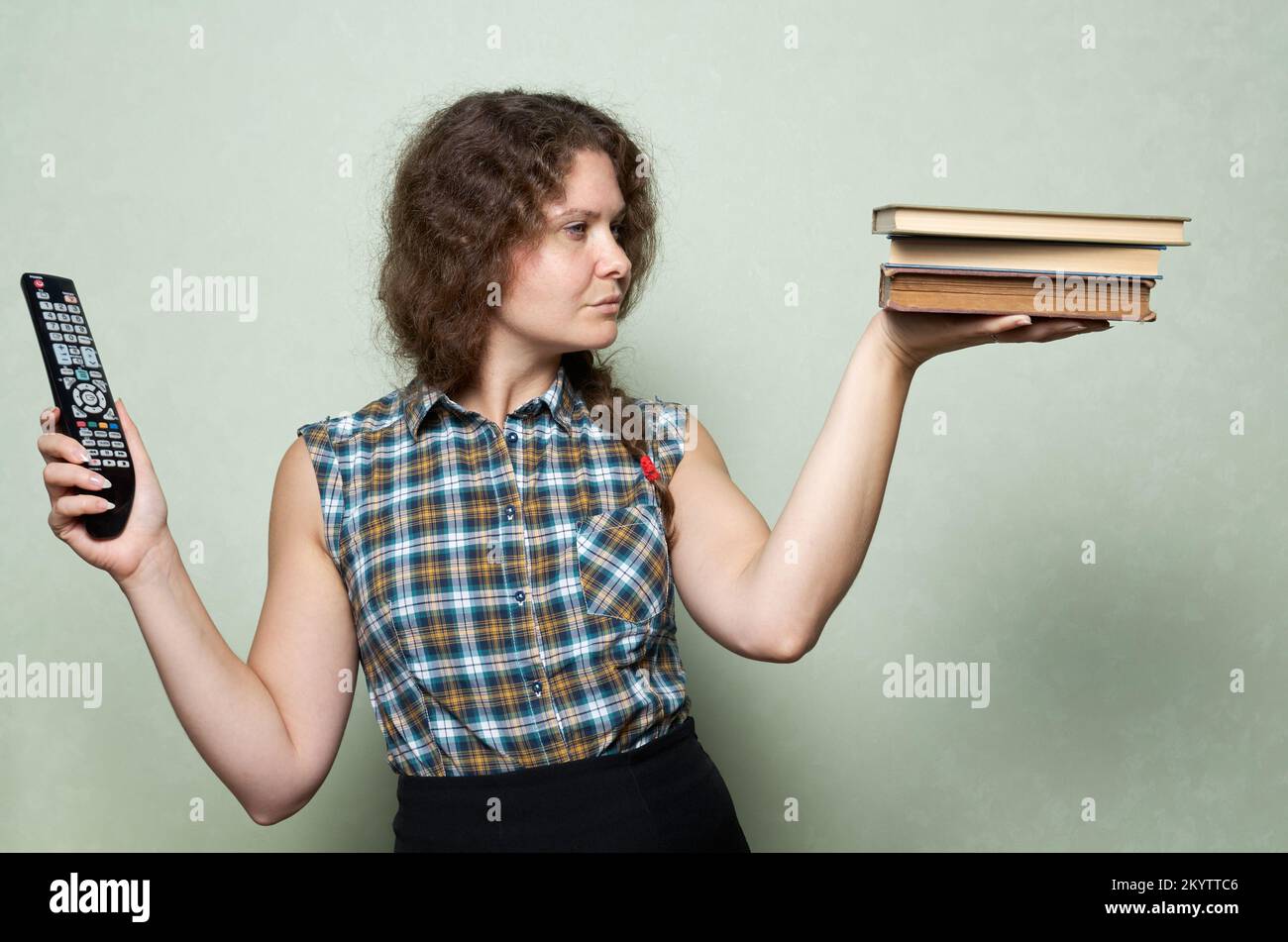 Book vs television. A woman makes a choice between books in one of her ...