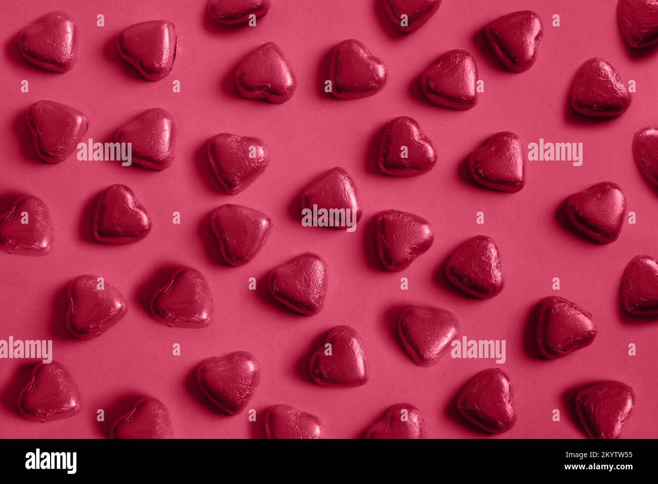 Pattern of chocolate sweets as heart in foil. Trending color of 2023 ...