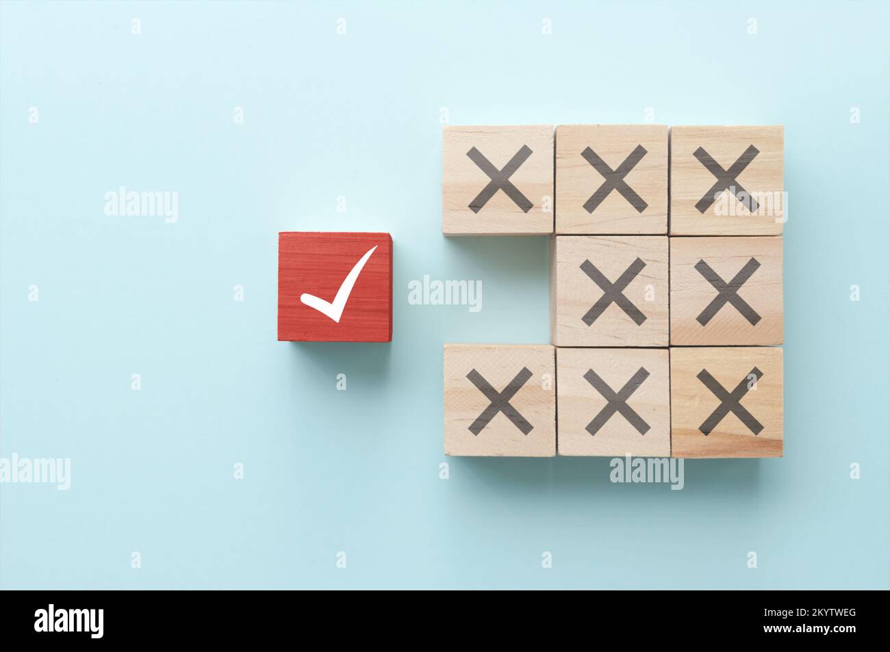 Red wooden block wtih tick standing out amongst crosses, solution ...