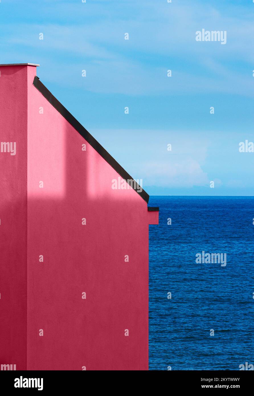 Viva magenta wall of building with a sea and sky background. Minimal ...