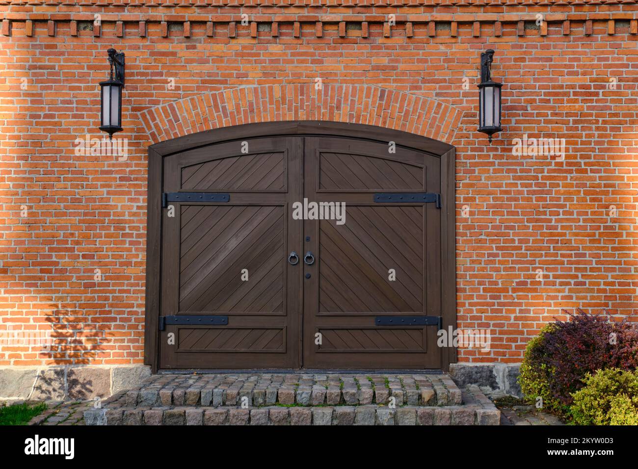 Old wooden gates on metal wrought iron canopies in brick building Stock ...
