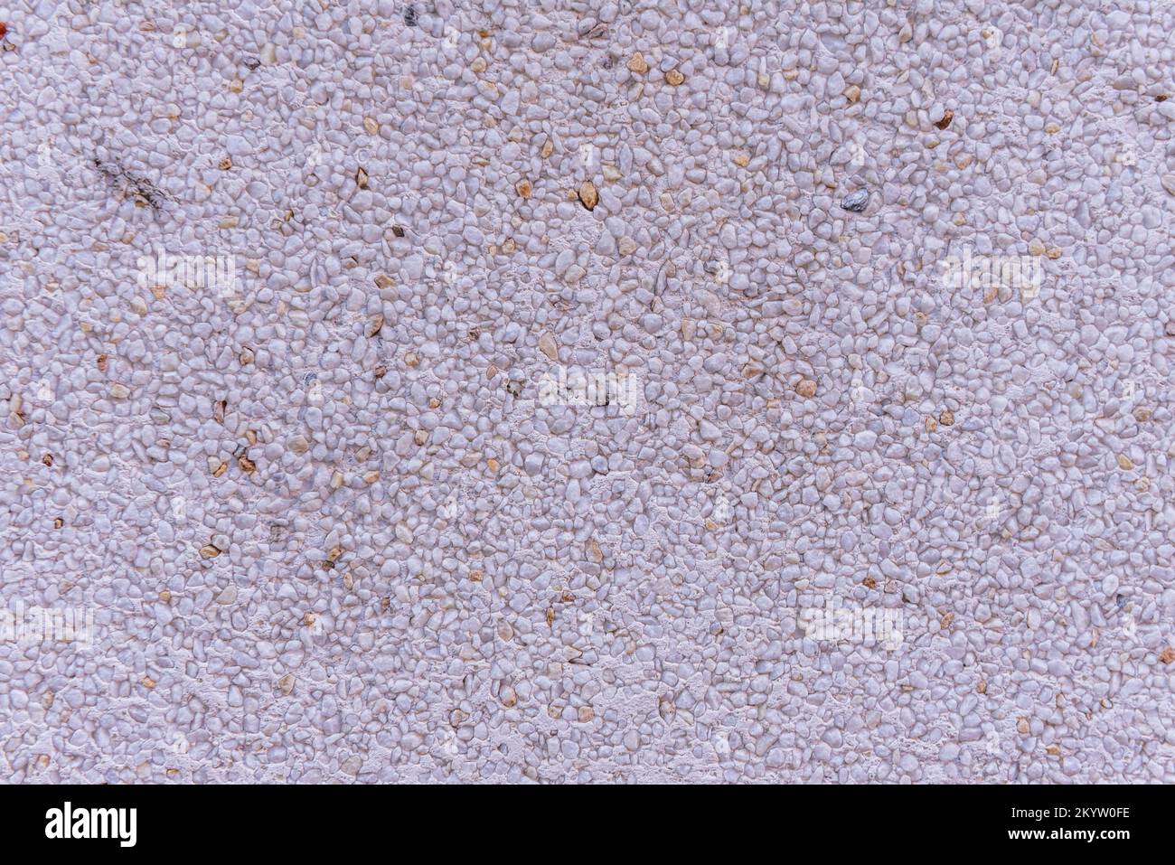 Cement wall with a multitude of stones integrated into the mass ...