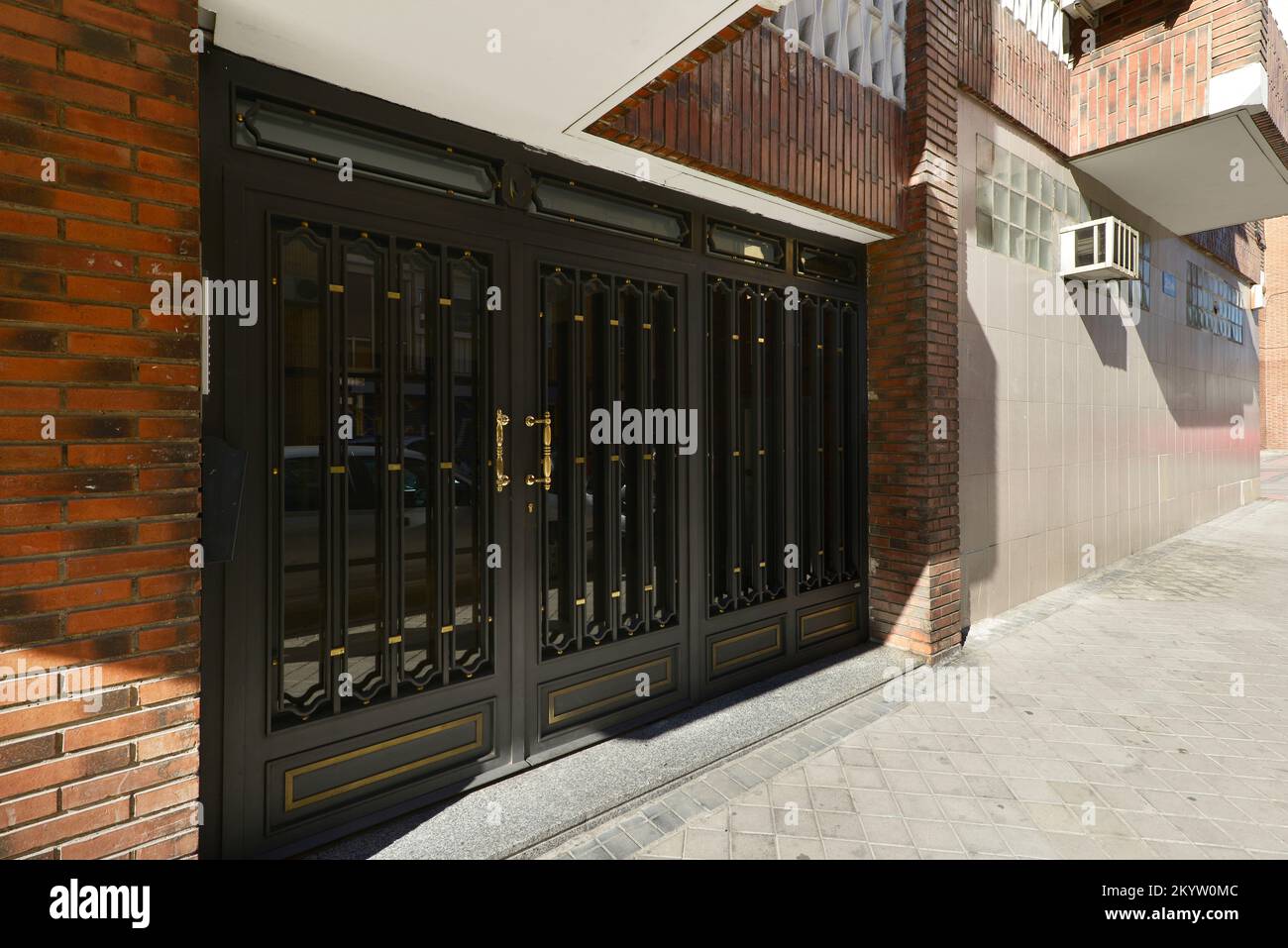 Metal doorway to the street painted black and gold handles in a single ...
