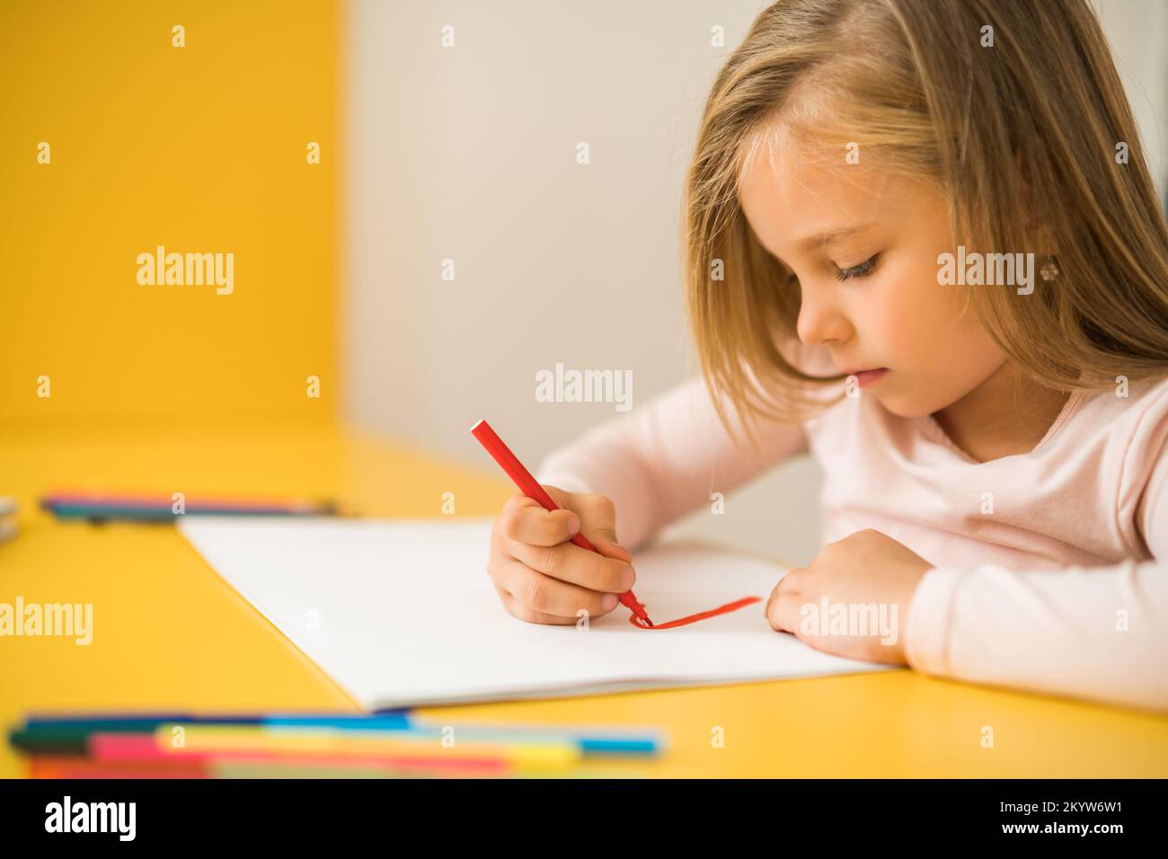 Beautiful little girl enjoys drawing at her home Stock Photo - Alamy
