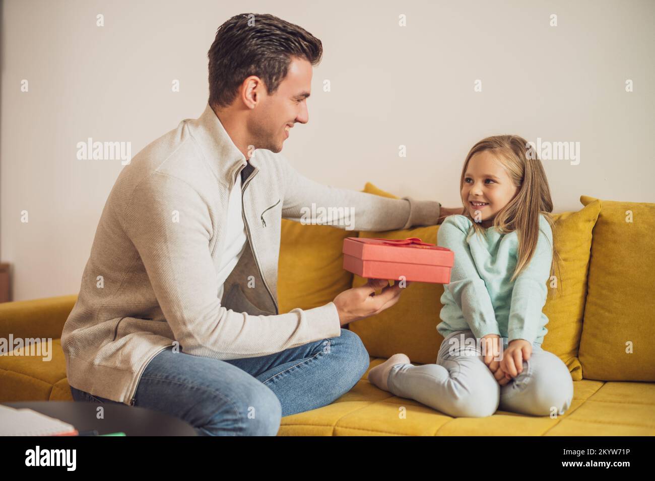 Happy daughter is getting gift from her father Stock Photo - Alamy