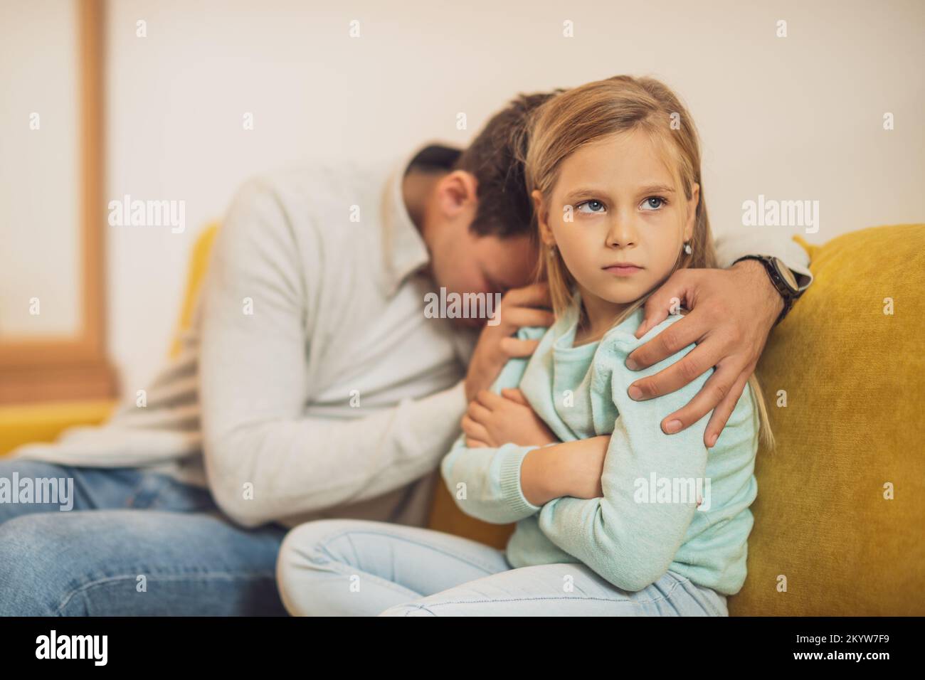 Little girl is angry after conflict with her father and he is trying to ...