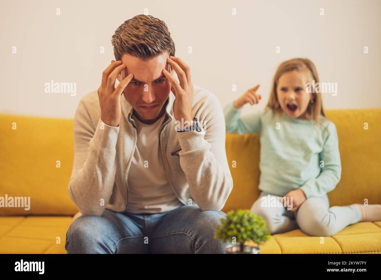 Stressed father is feeling desperate because of screaming his daughter ...