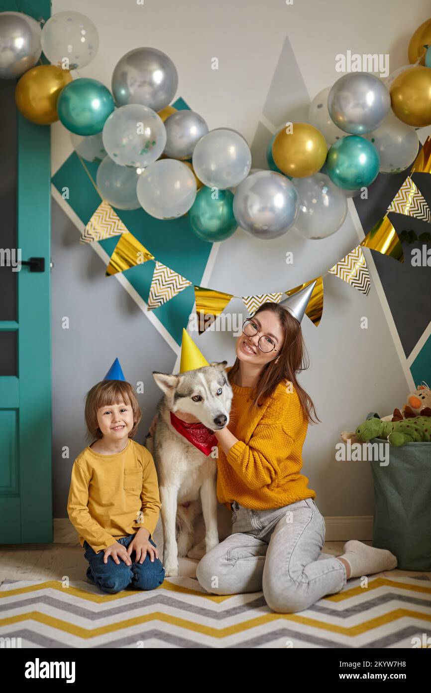 Dog pet birthday, family mother and child hug their dog congratulating ...
