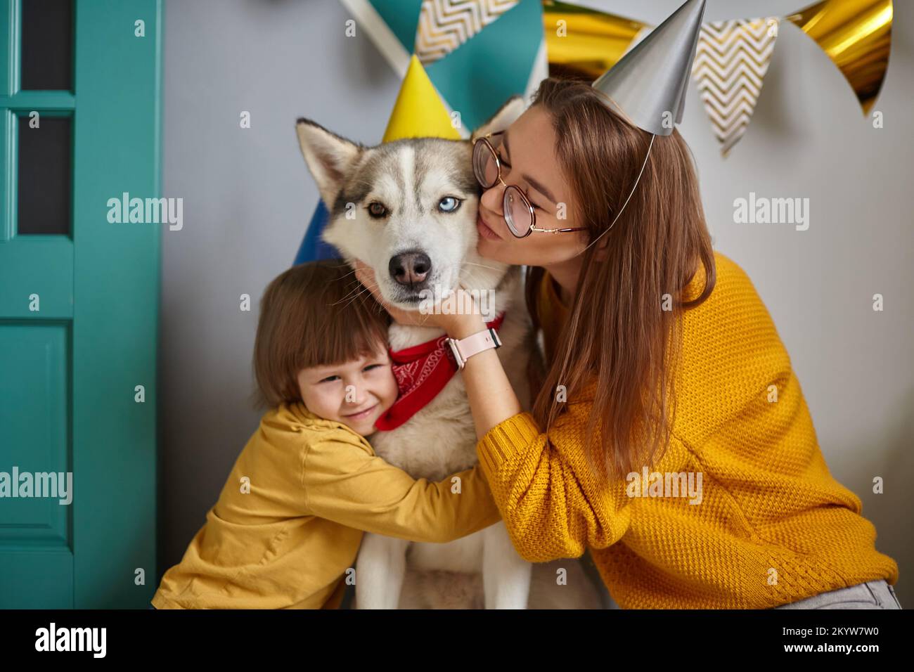 Dog pet birthday, family mother and child hug and kiss their dog ...