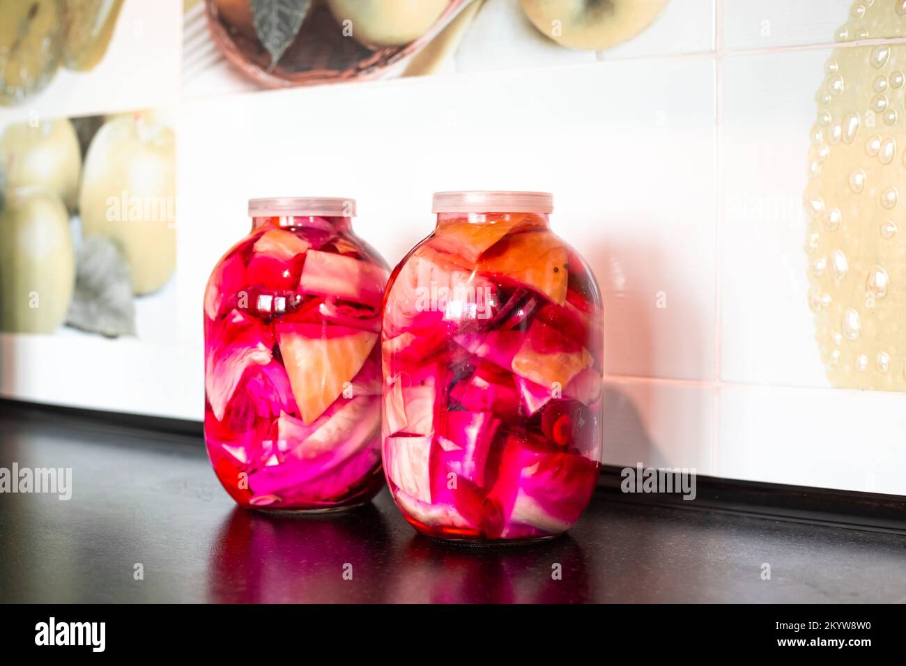 canned white cabbage with beets in glass jars on the kitchen countertop ...