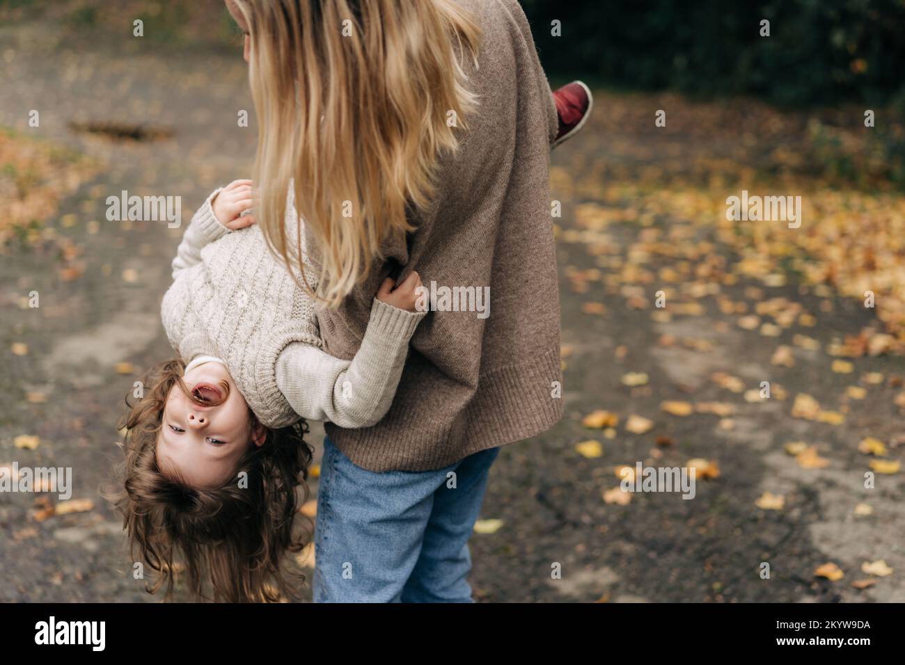 Happy young mother and little daughter are playing and fooling around ...