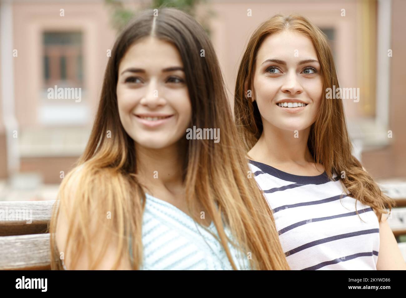 Two pretty female friends smiling, while hanging out in city Stock ...
