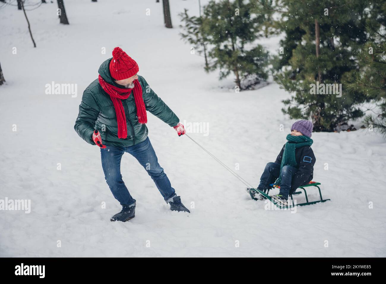 Photo of funny cheerful dad small kid wear windbreakers dragging ...