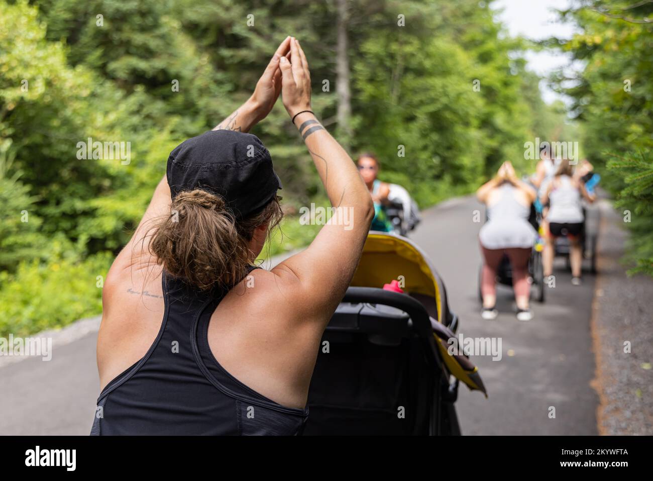 Backside photo taken of a mother taking aerobic lessons with group of ...
