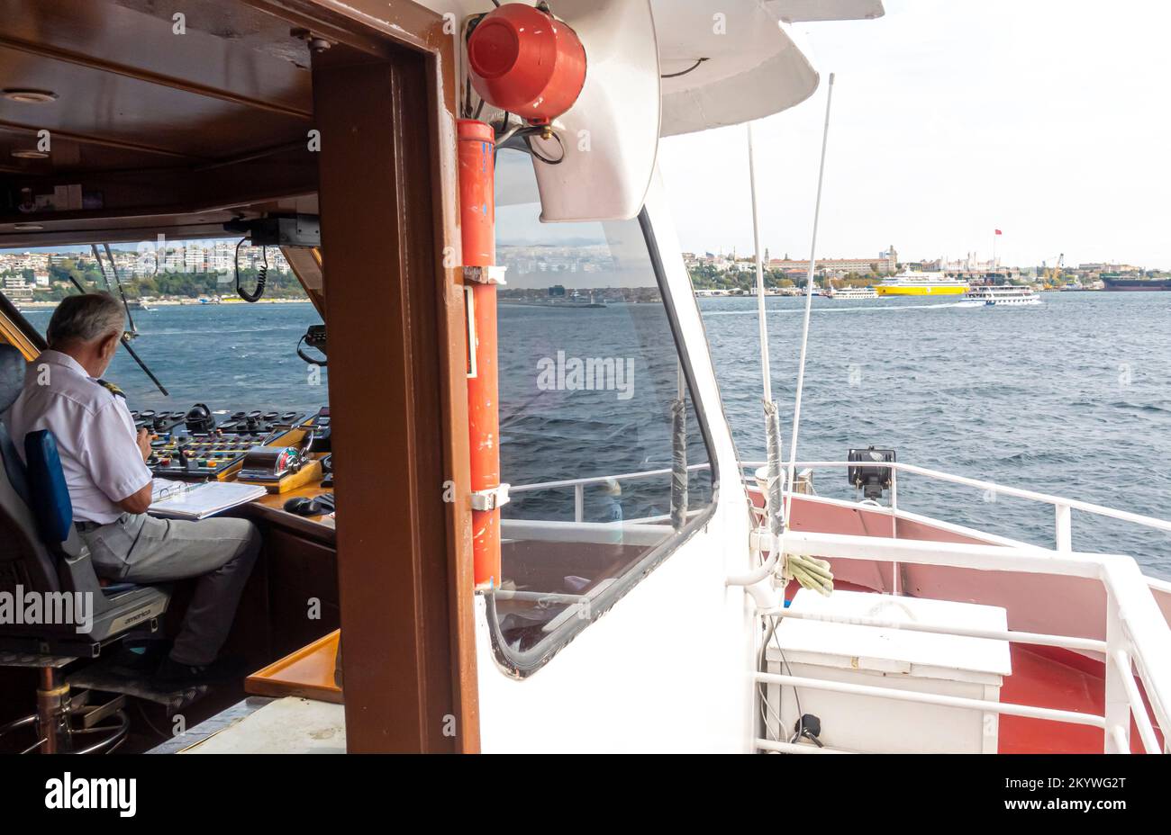 Cruise boat captain in the captain's booth with ship journal. Bosphorus ...