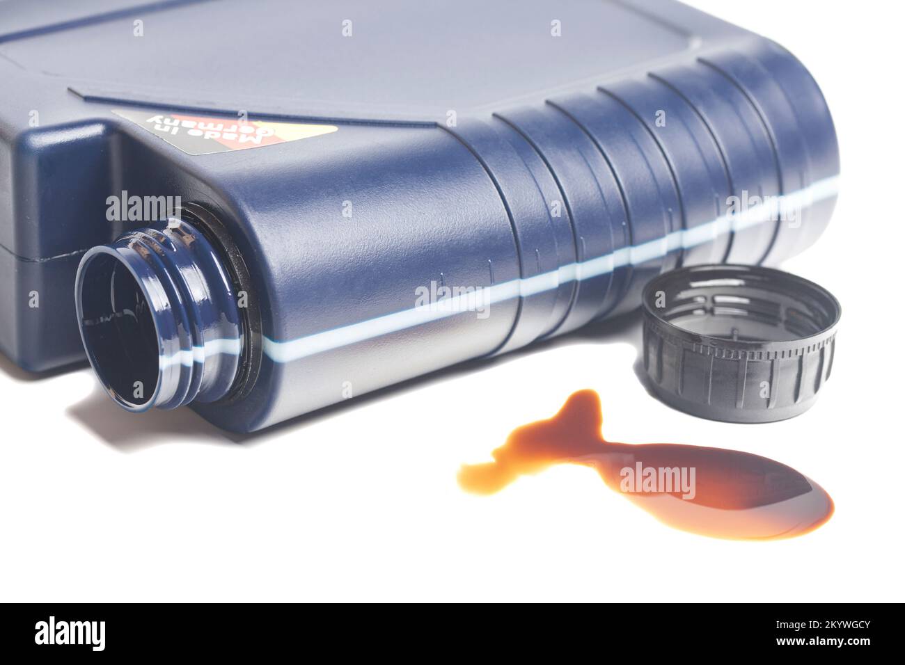 open engine oil bottle with a puddle of engine oil isolated on white ...