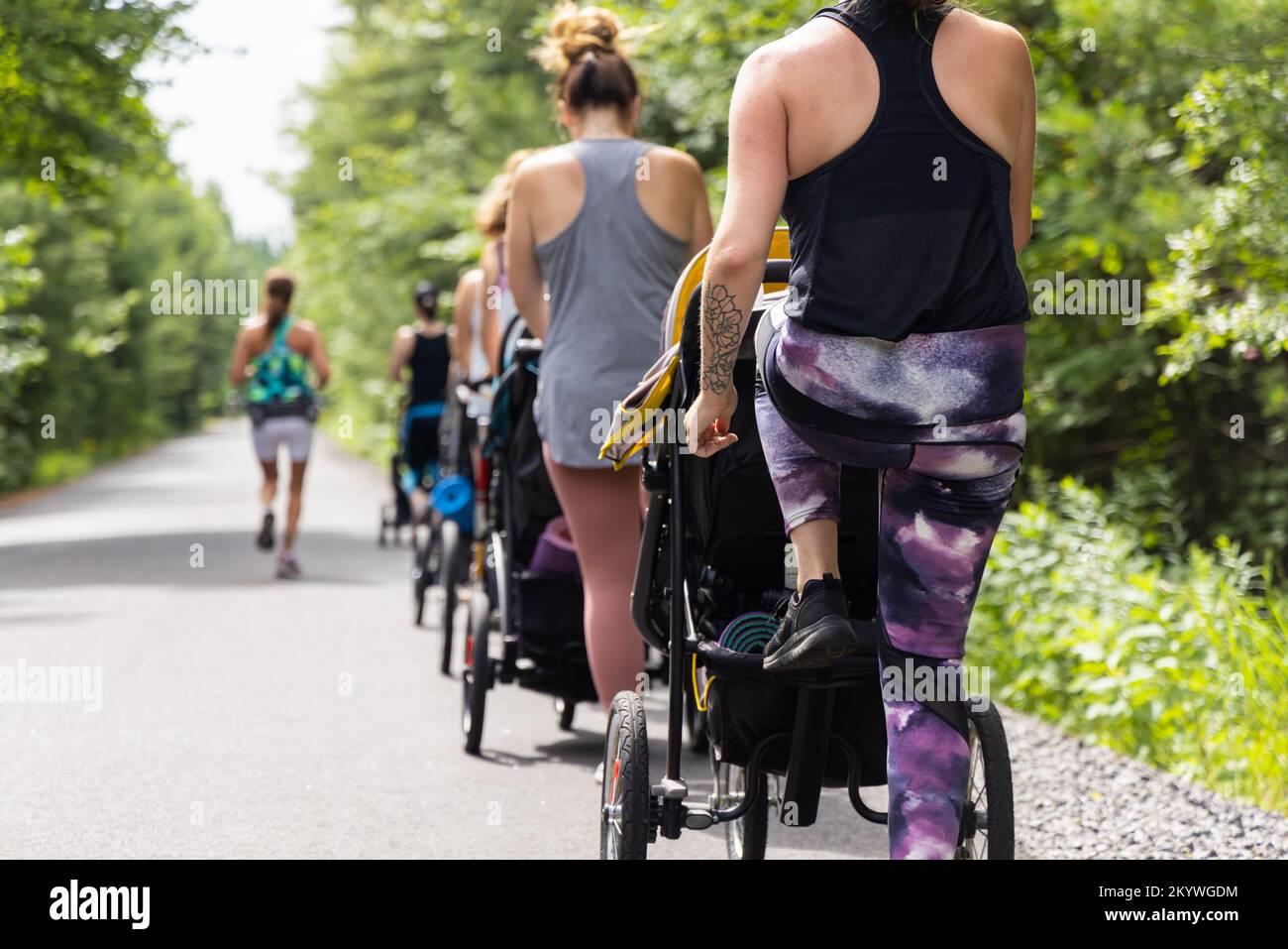 Backside photo taken from a group of mothers working out outside with ...