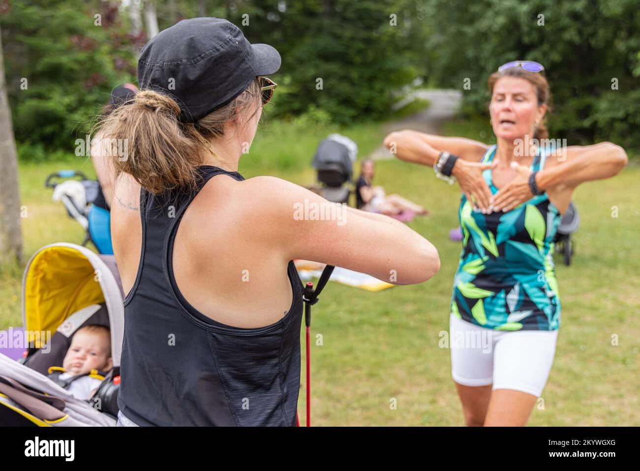 Backshot of mother listening to the instructor who is teaching her how ...