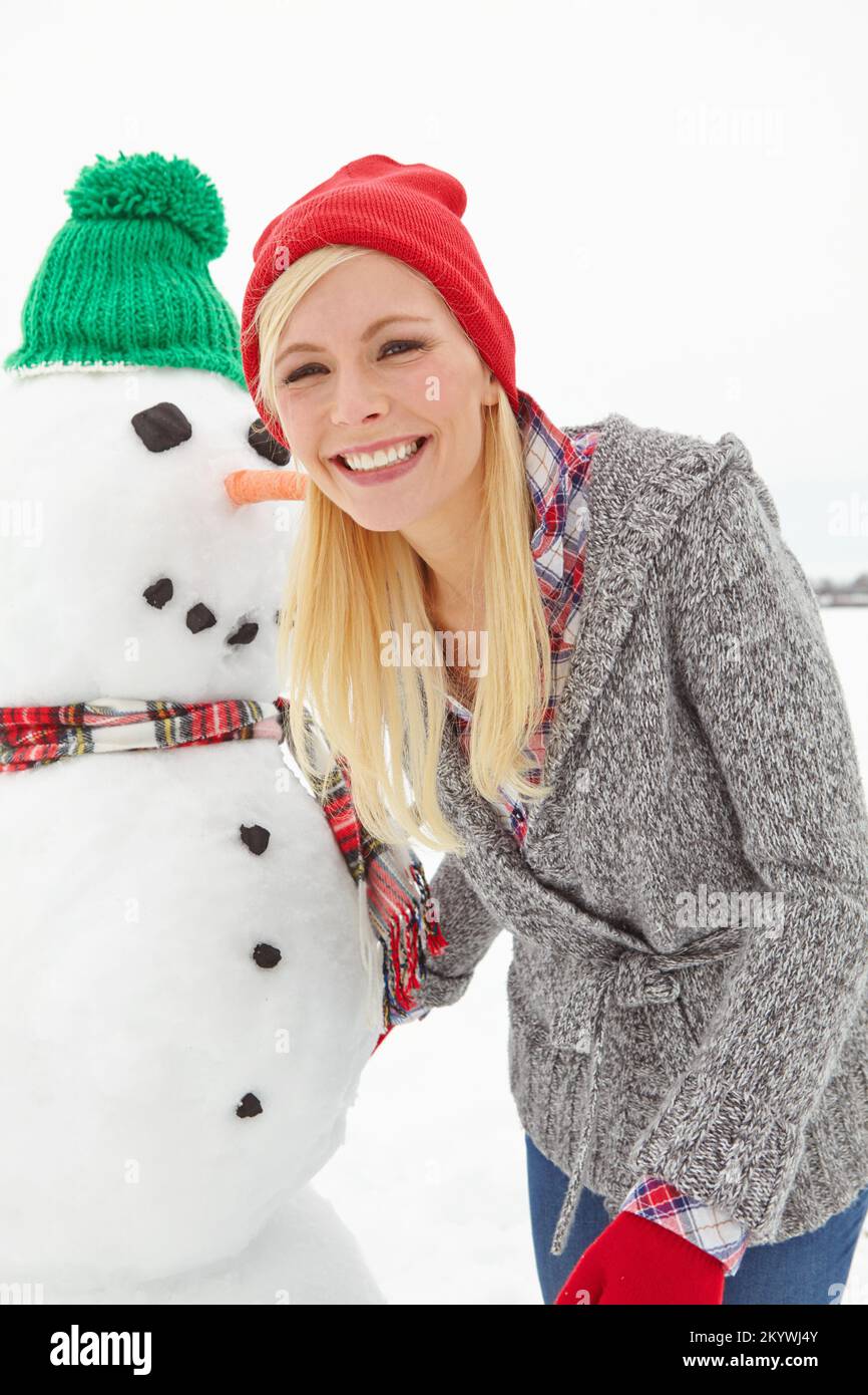Portrait, winter and woman with a snowman during Christmas, outside in ...