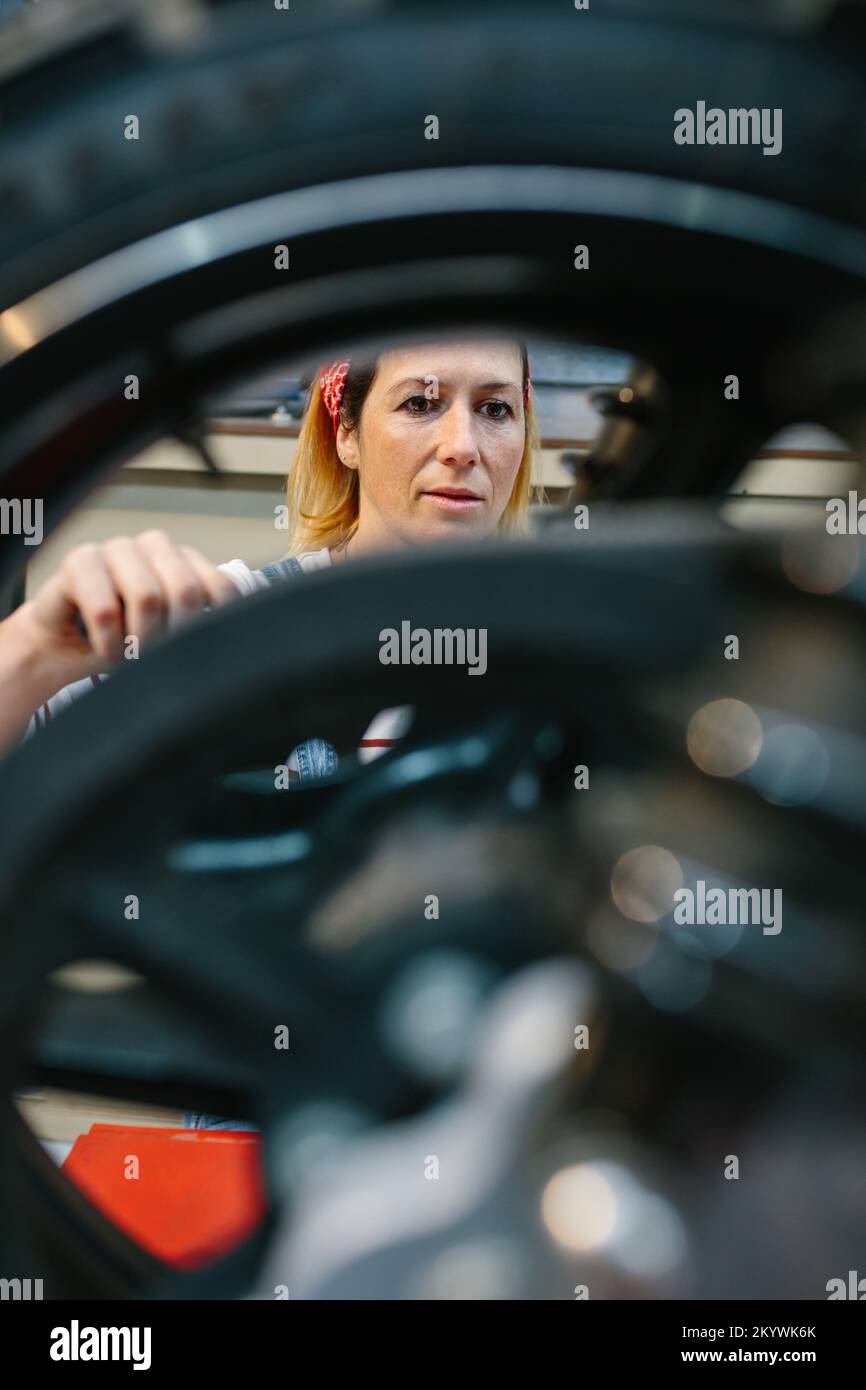 Mechanic woman repairing motorcycle disk brake on factory Stock Photo ...