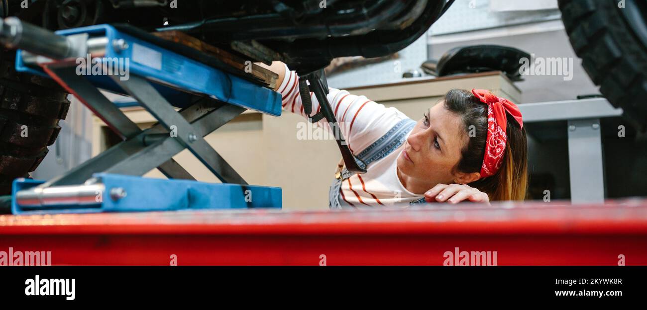 Mechanic woman checking motorcycle over platform Stock Photo - Alamy