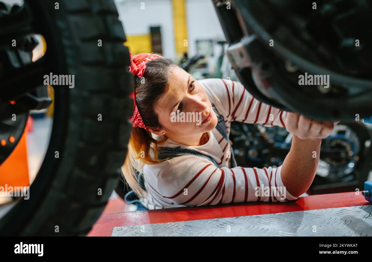 Mechanic woman checking motorcycle on factory Stock Photo - Alamy