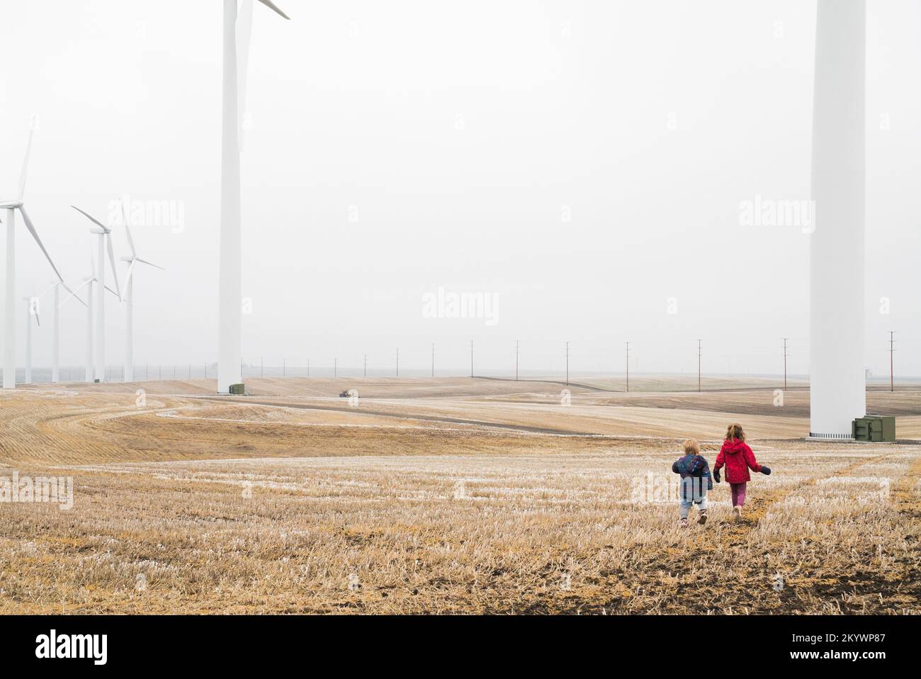 Two children walk toward a line of giant windmills Stock Photo - Alamy